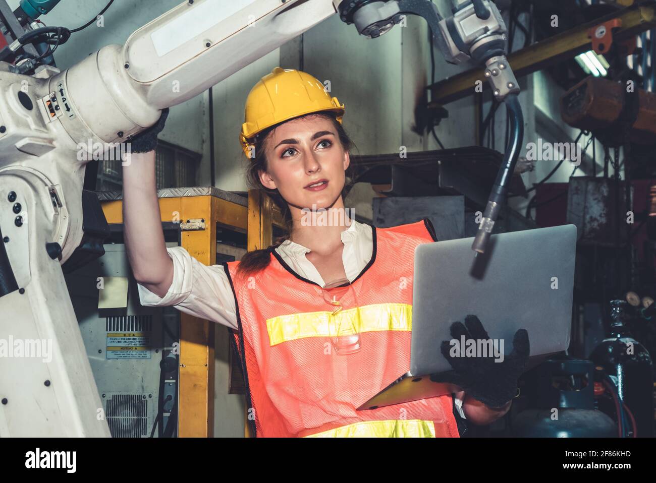 Smart factory job worker control robotic arm in manufacturing workshop ...