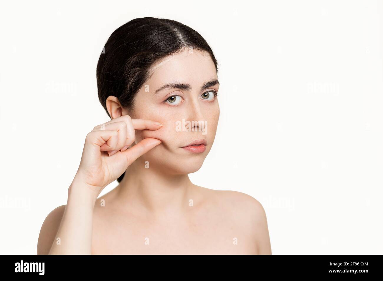 Portrait of a woman pulling the skin on her face with her fingers ...