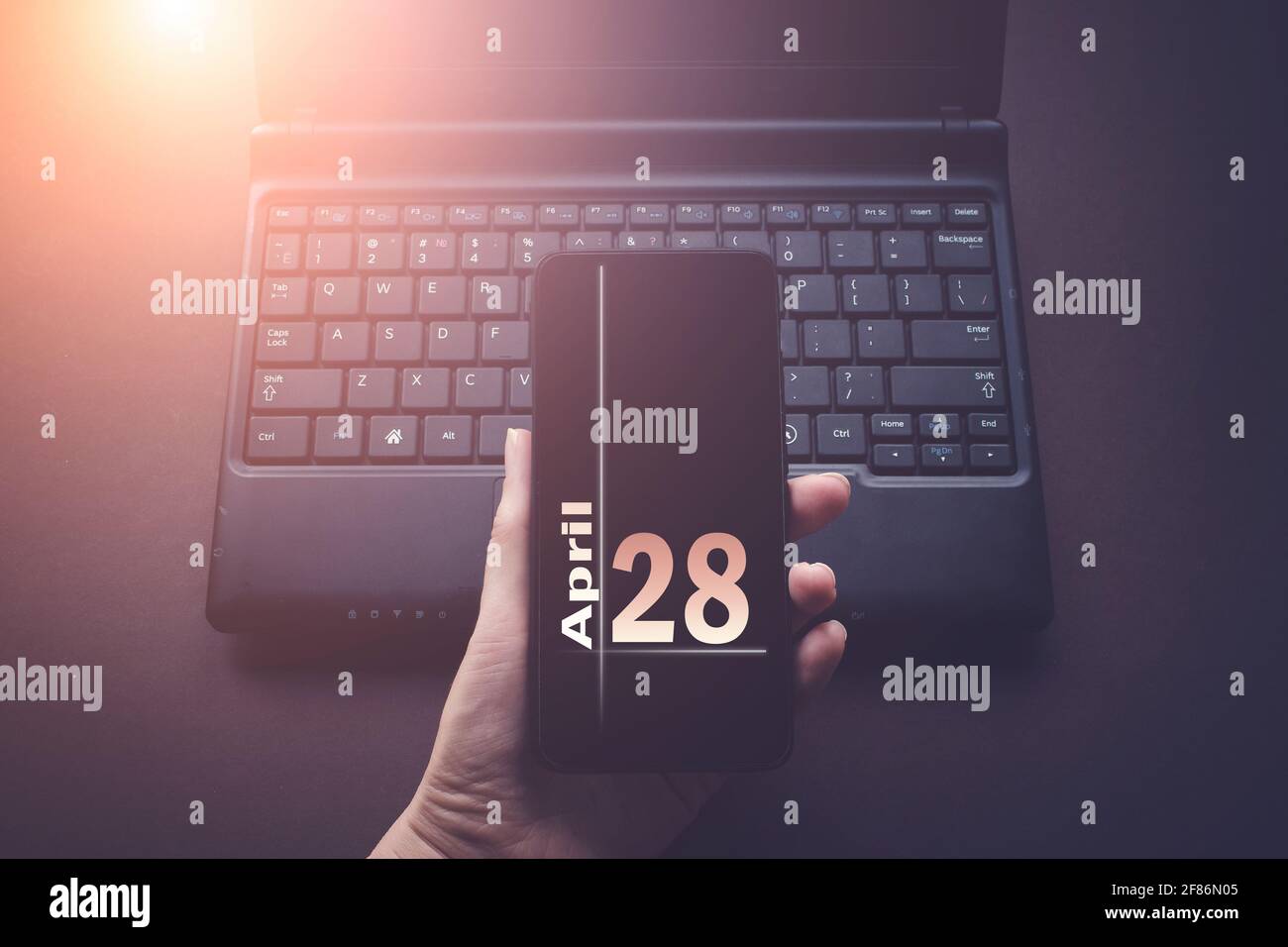 April 28th. Day 28 of month, Calendar date. Hand Holding Mobile Phone ...