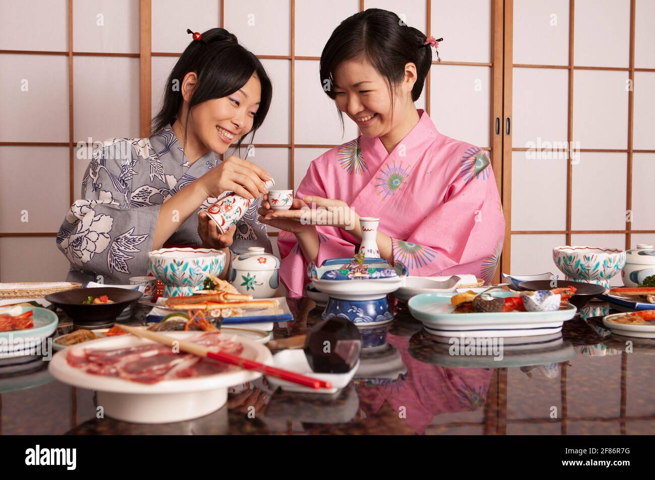 Happy young Japanese women in kimonos drinking tea with lunch Stock ...