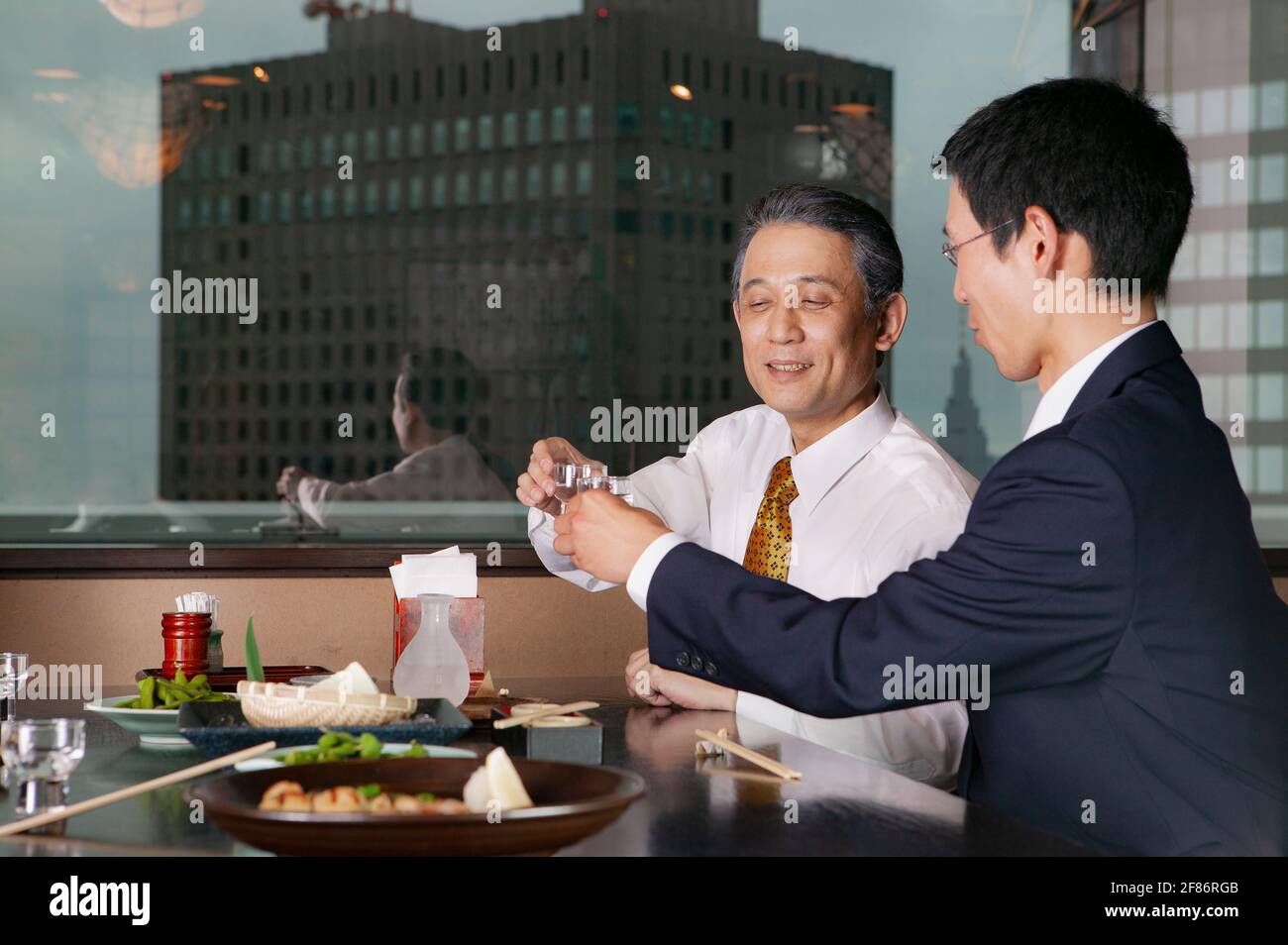 Japanese businessmen drinking with lunch in highrise restaurant Stock ...