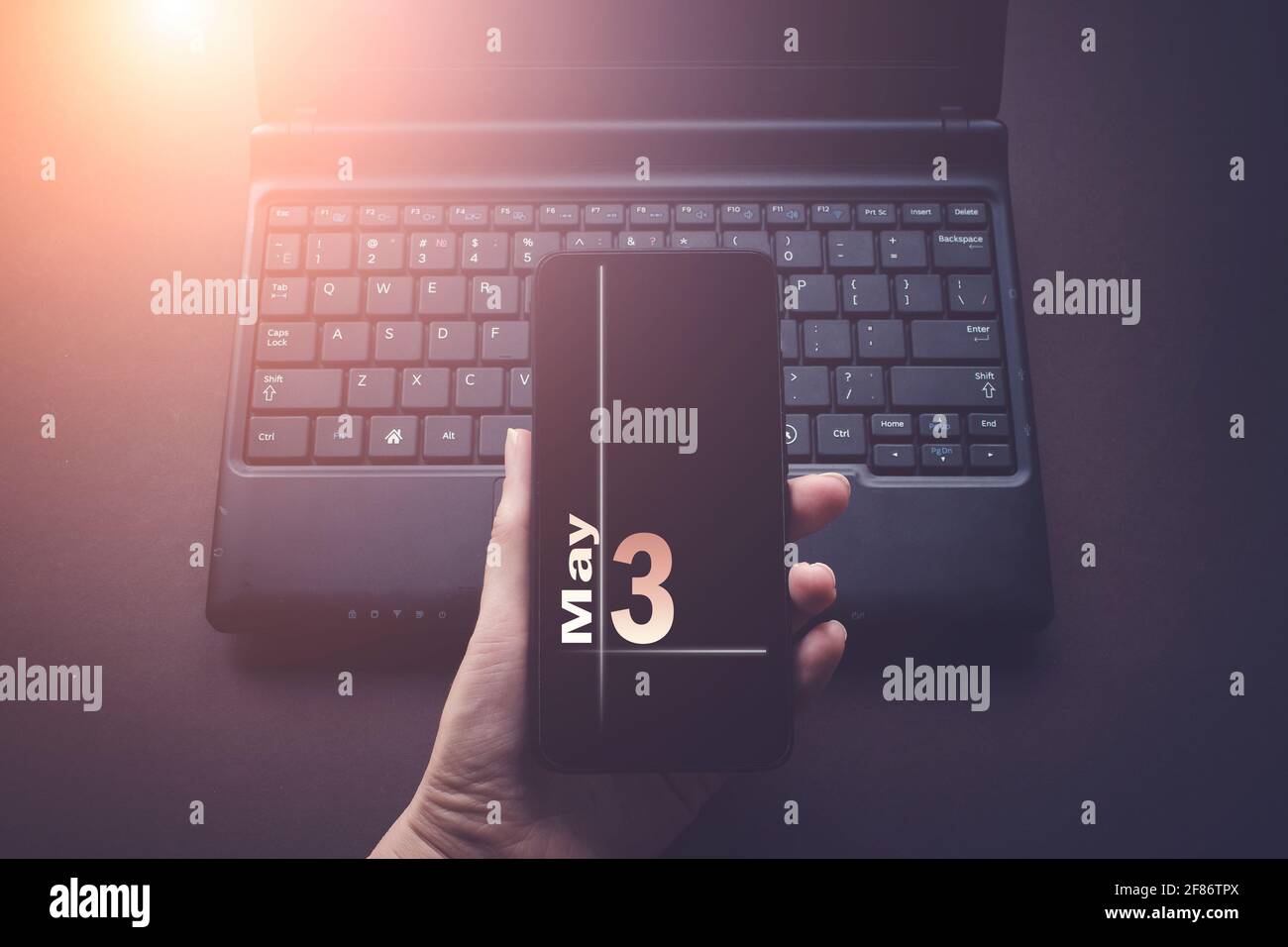 May 3rd. Day 3 of month, Calendar date. Hand Holding Mobile Phone on ...