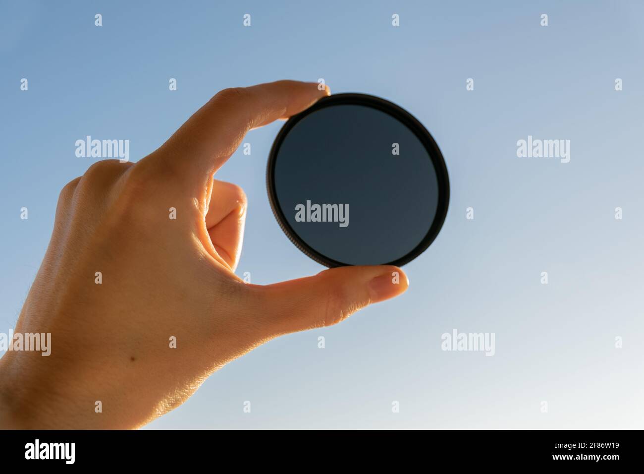 Hand hold ND-filter over blue sky background Stock Photo - Alamy