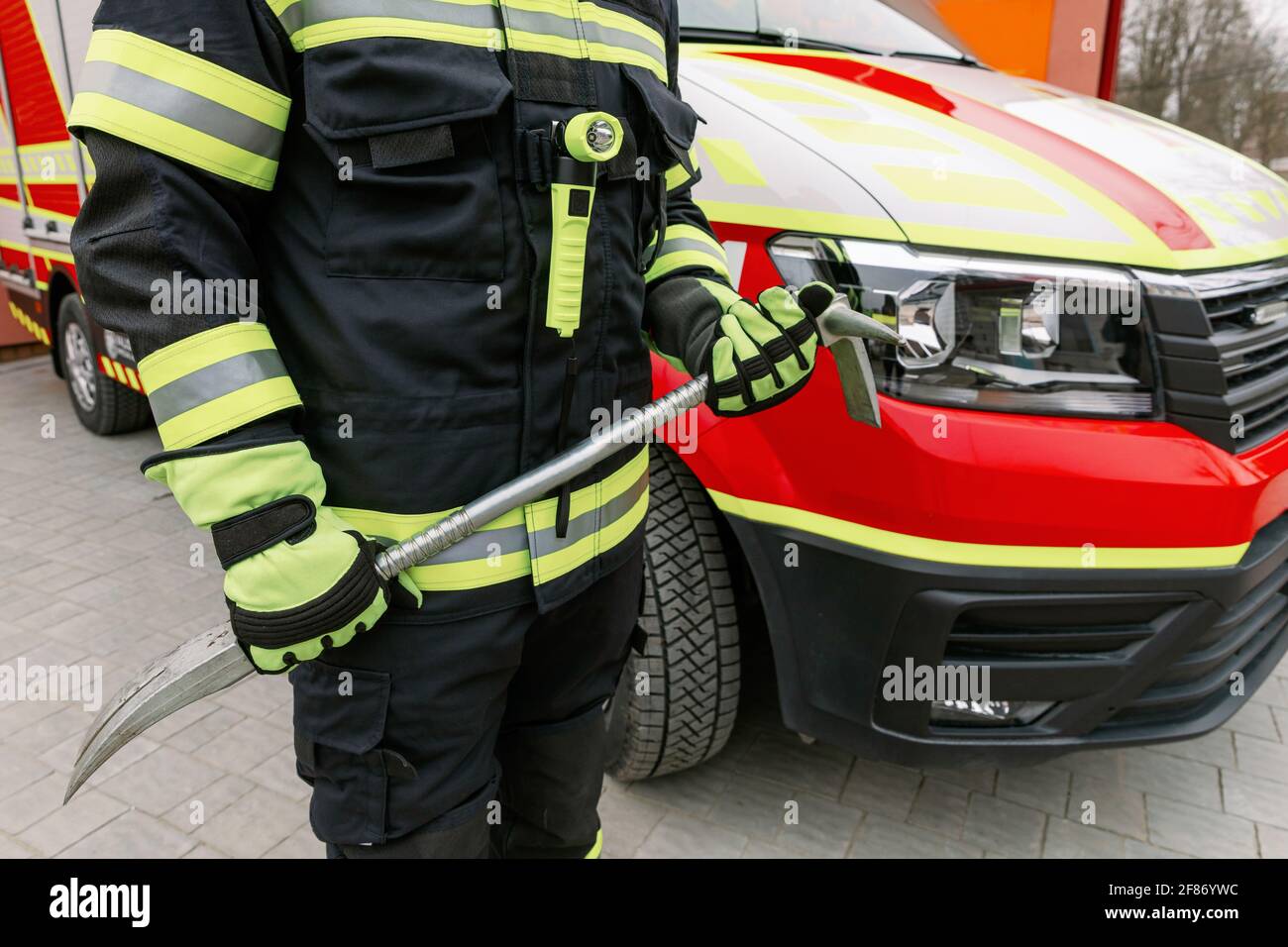 A man of strong physique in uniform and helmet stands by a rescue ...