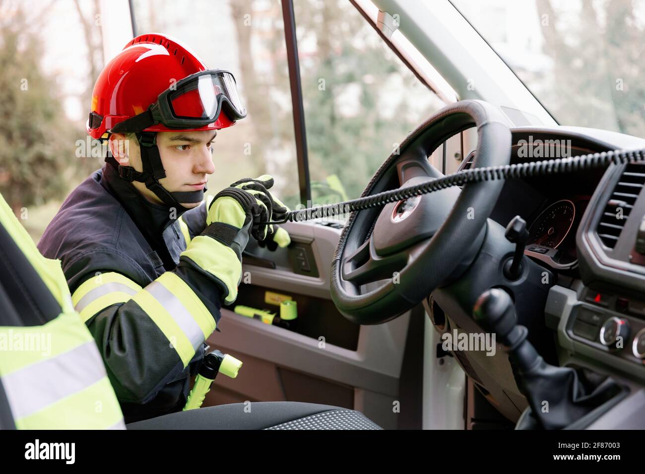 A man of strong physique in uniform and helmet stands by a rescue ...