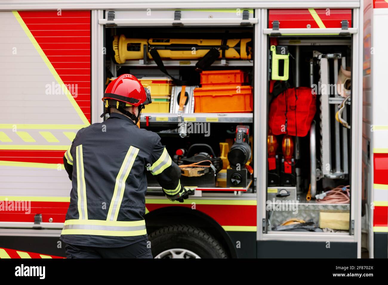 A man of strong physique in uniform and helmet stands by a rescue ...