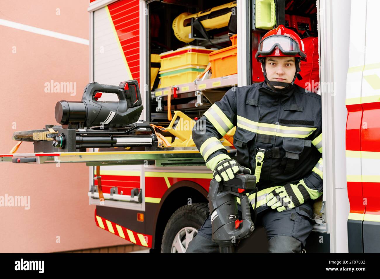 A man of strong physique in uniform and helmet stands by a rescue ...