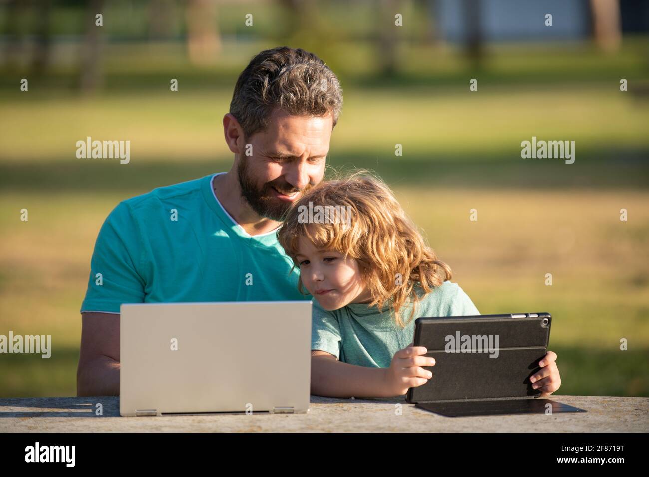 Father teaching son to use laptop, dad and school boy child looking ...