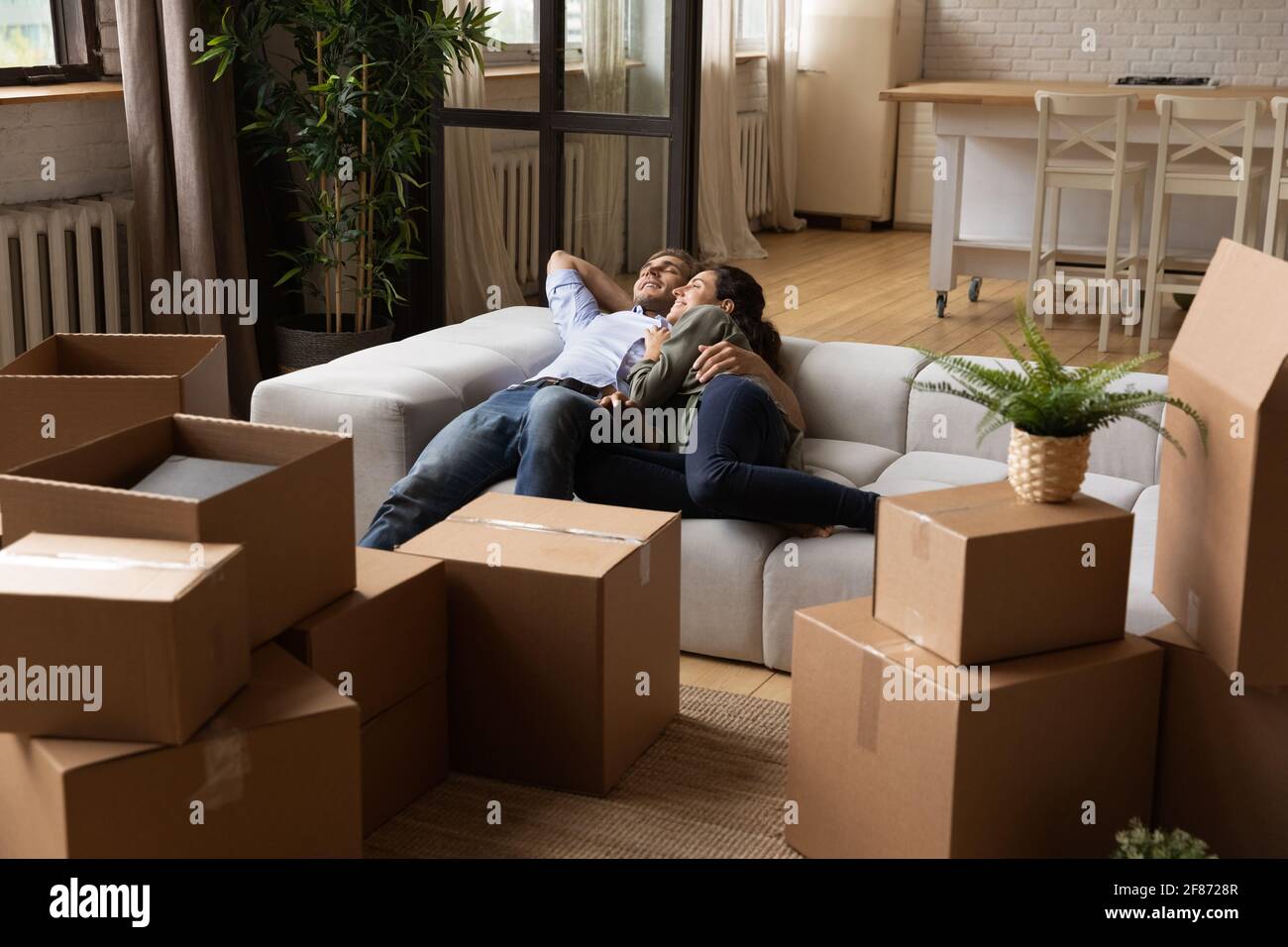 Happy relaxed family resting after moving day in new apartment Stock ...