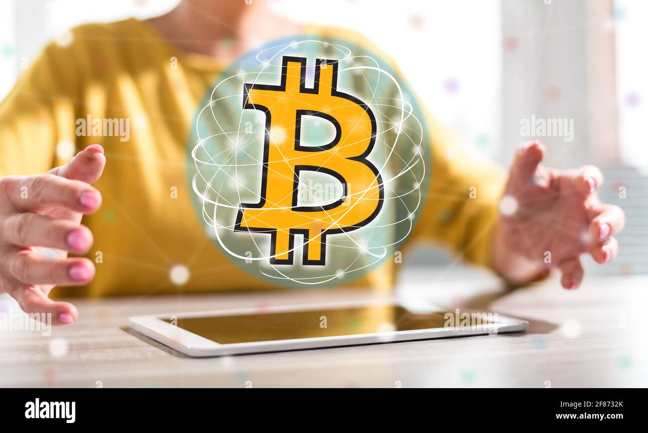 Digital tablet with bitcoin currency concept between hands of a woman ...