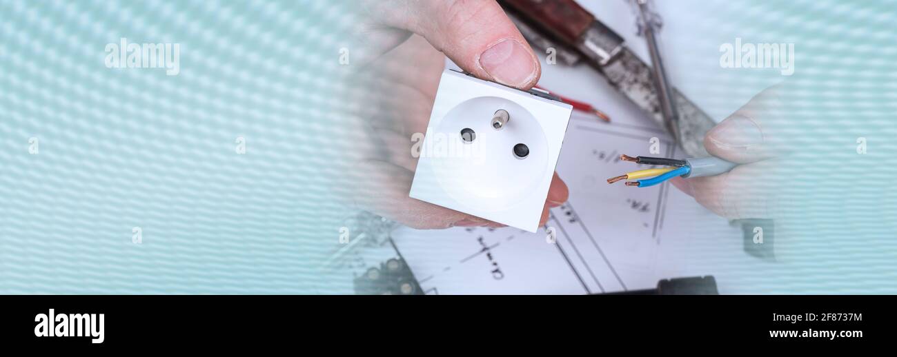 Hand holding an electrical outlet and a power cable; panoramic banner ...