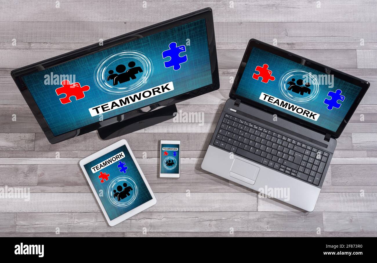 Teamwork concept shown on different information technology devices ...