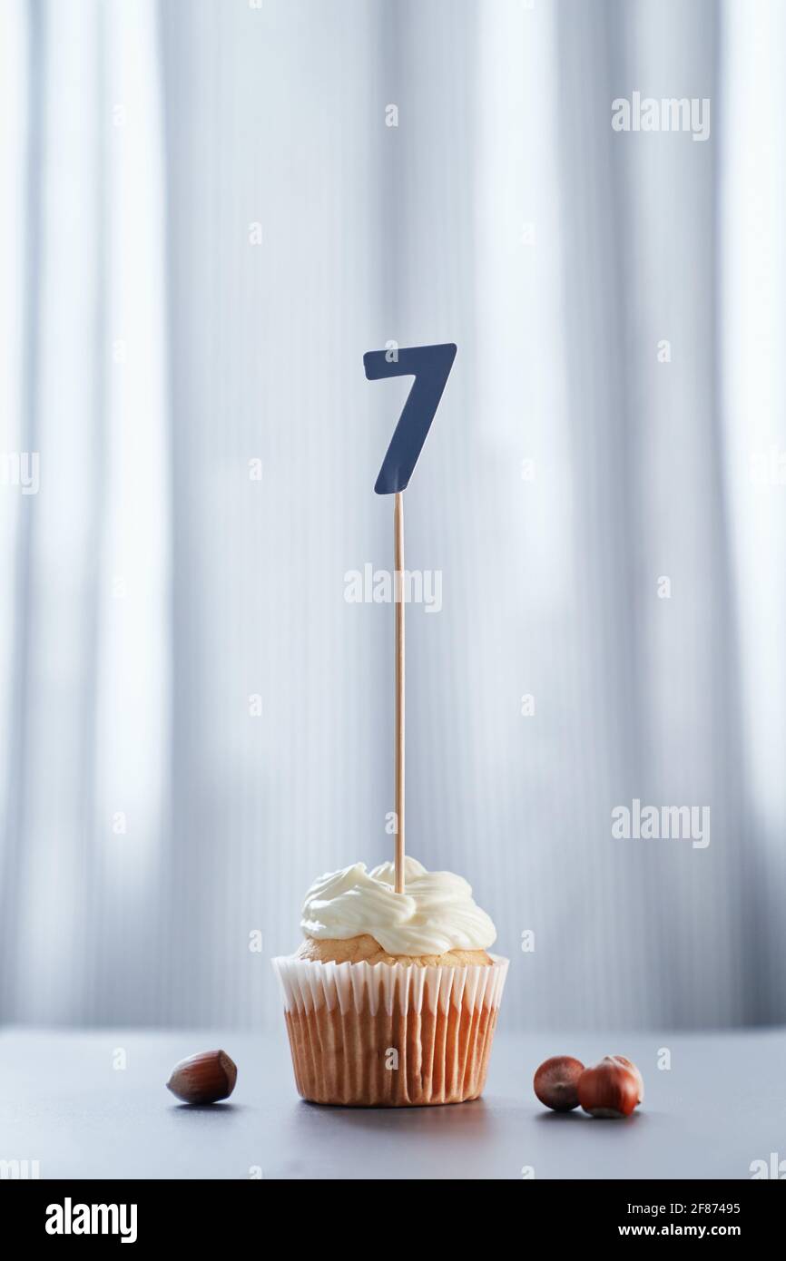 Tasty homemade vanilla cupcake or muffin with creamy topping and number ...