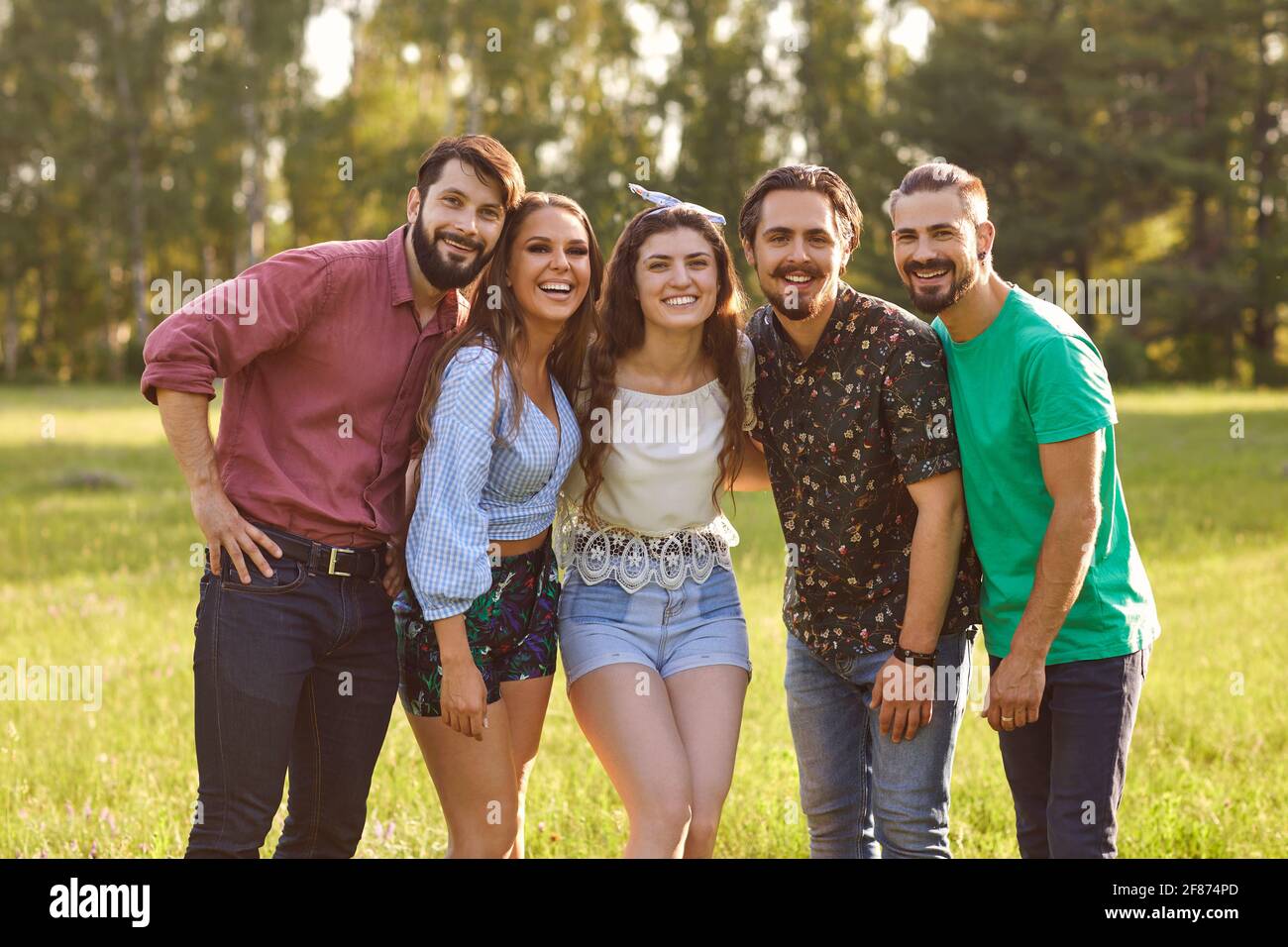 Portrait of happy millennial friends looking at camera in countryside ...