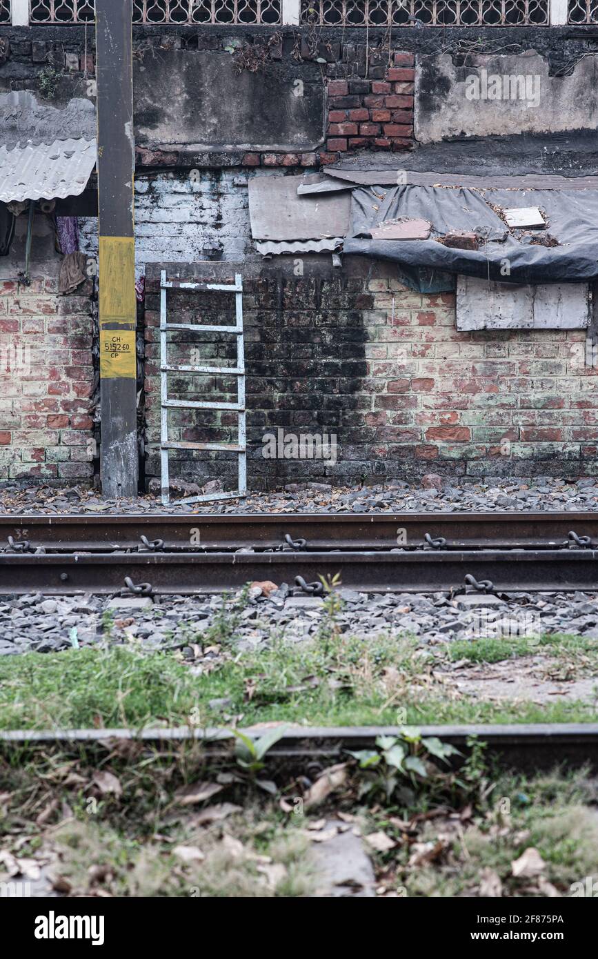 Vertical shot of railway tracks with ladder leaning on a weathered ...