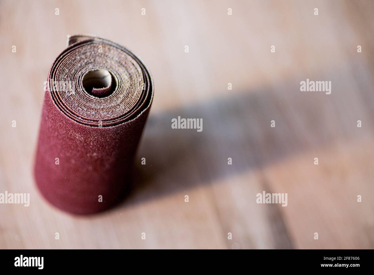 Close up shot of a sandpaper roll on a wooden table Stock Photo - Alamy