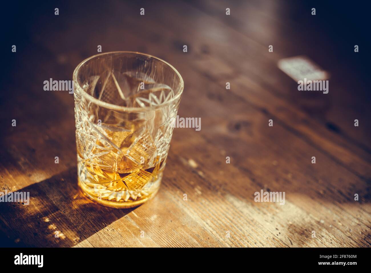 Close up shot of a whisky glass on a wooden surface Stock Photo - Alamy