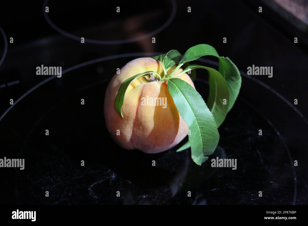 Fresh peach with leaves on a dark background Stock Photo - Alamy