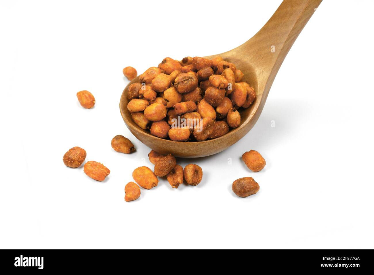 Pile of toasted salted corn in a wooden spoon on a white background ...
