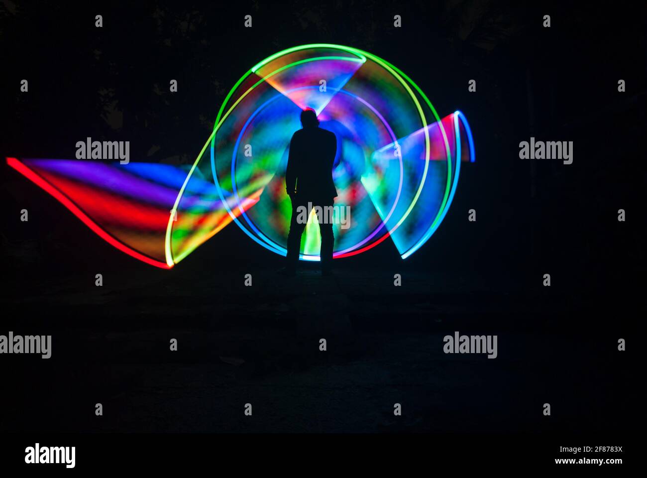 One person standing alone against beautiful color circle LED light ...