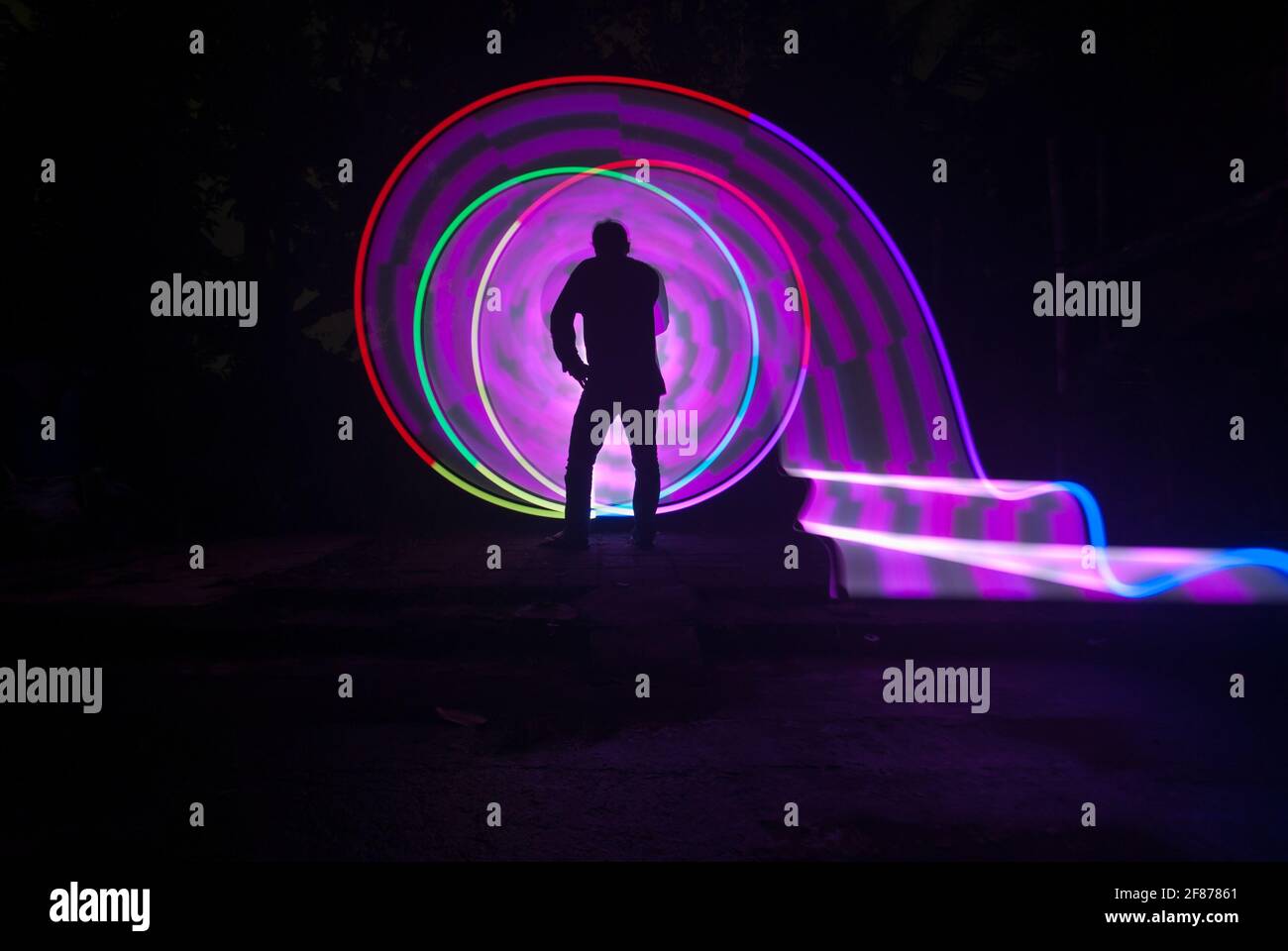 One person standing alone against beautiful color circle LED light ...