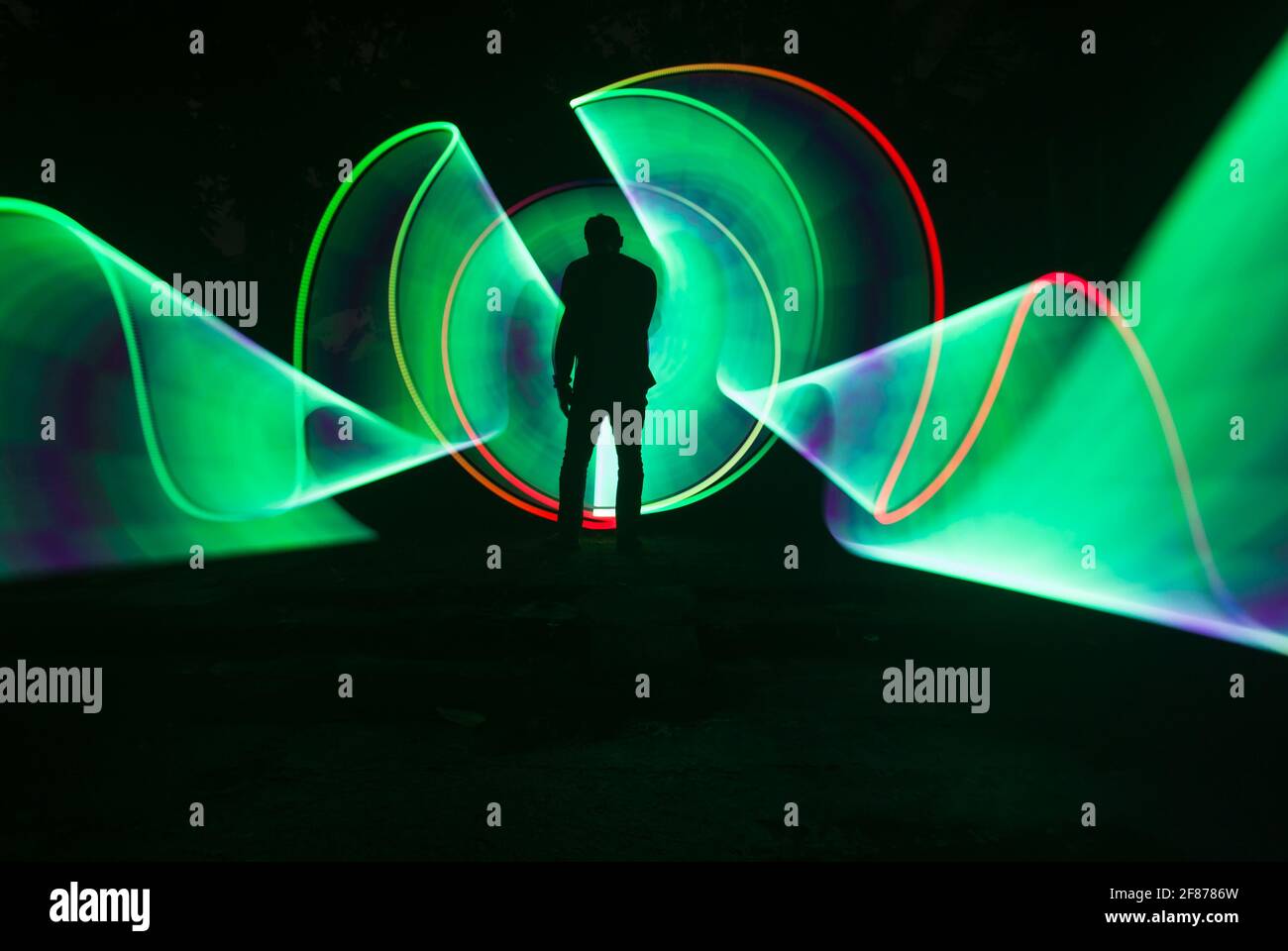 One person standing alone against beautiful color circle LED light ...