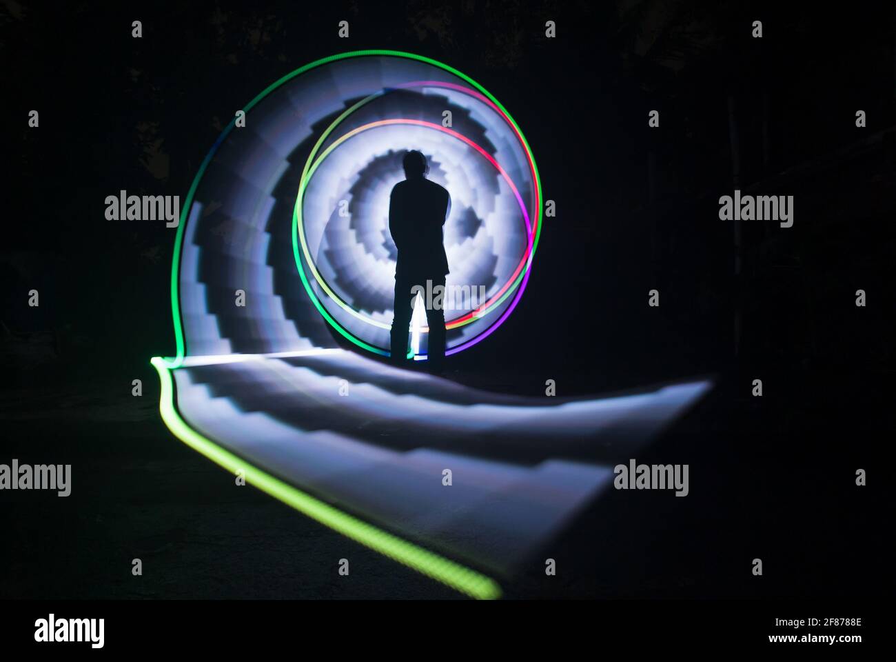 One person standing alone against beautiful color circle LED light ...