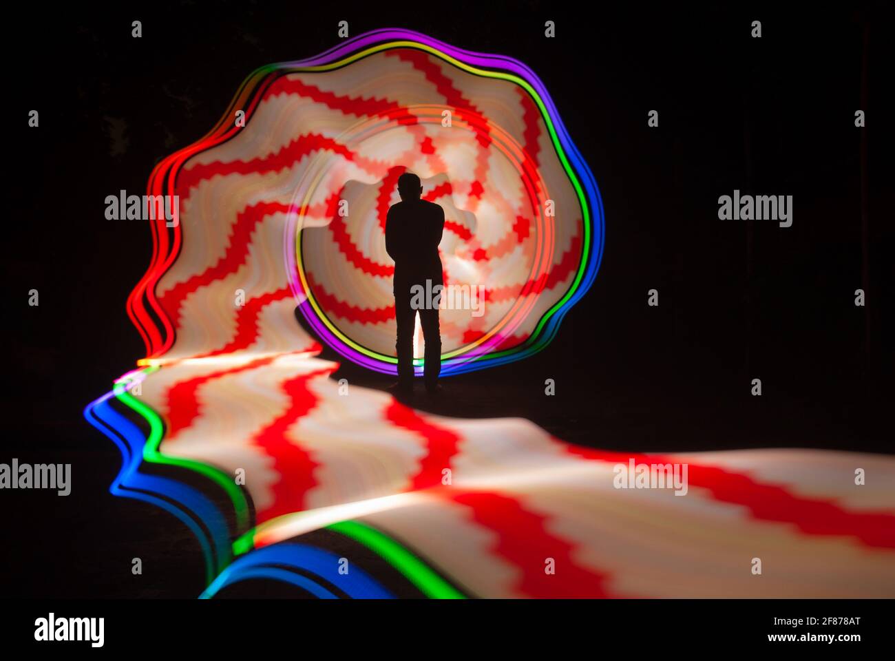 One person standing alone against beautiful color circle LED light ...