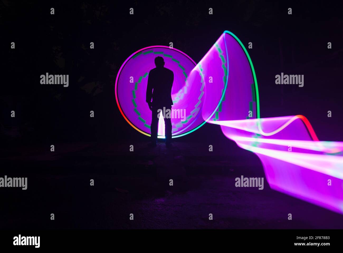 One person standing alone against beautiful color circle LED light ...