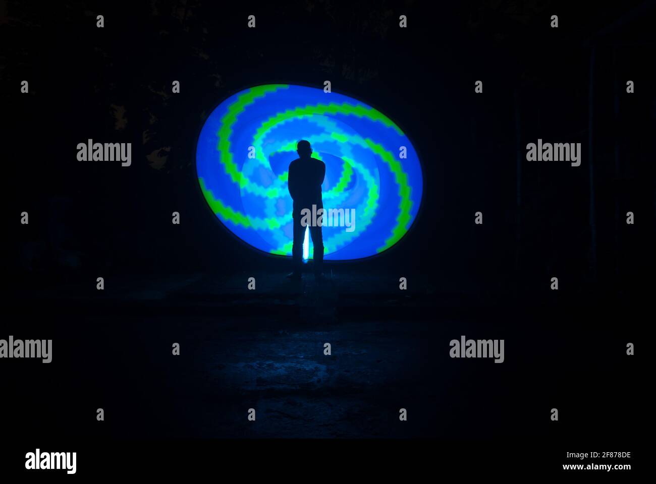 One person standing alone against beautiful color circle LED light ...