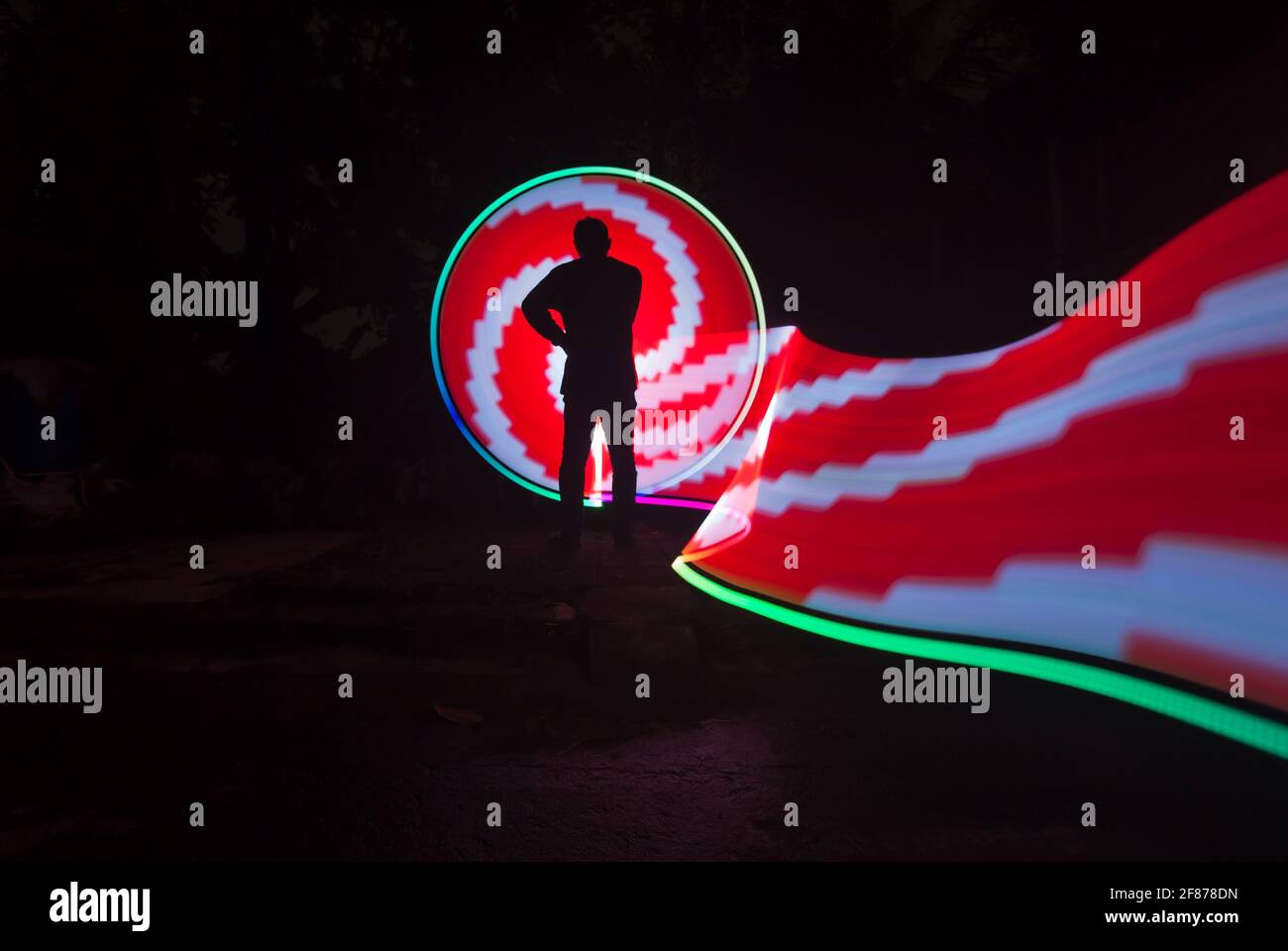 One person standing alone against beautiful color circle LED light ...