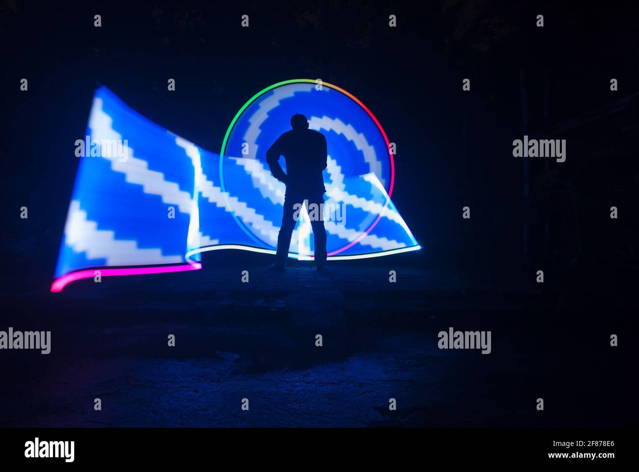 One person standing alone against beautiful color circle LED light ...