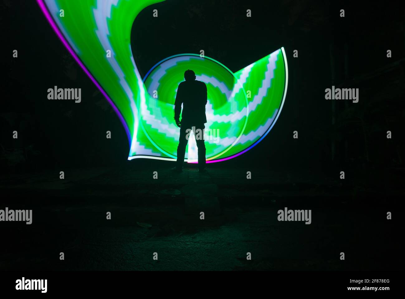 One person standing alone against beautiful color circle LED light ...