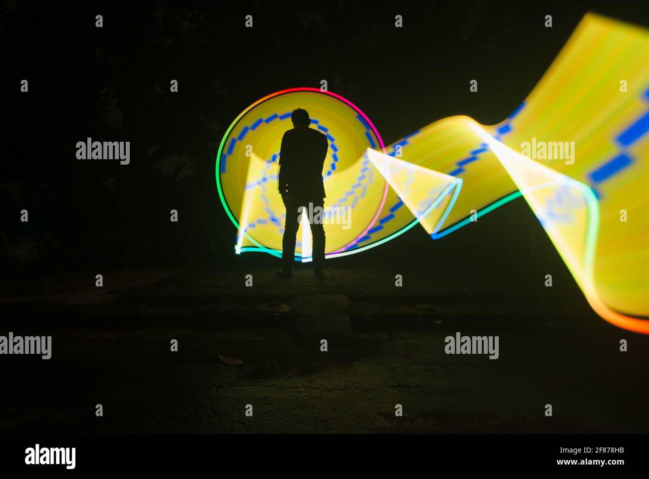 One person standing alone against beautiful color circle LED light ...
