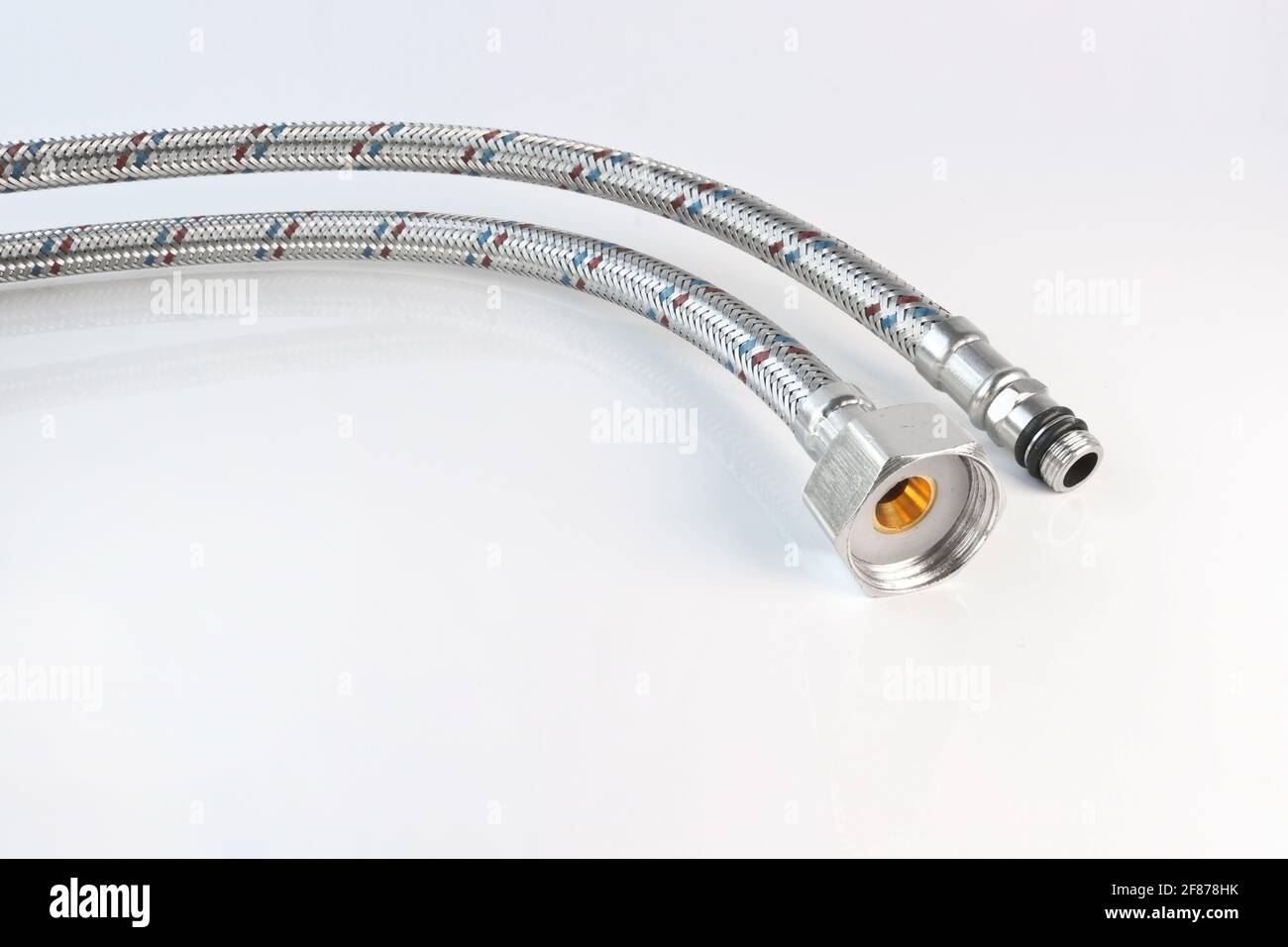 Flexible water line with connections on a light background. Plumbing ...