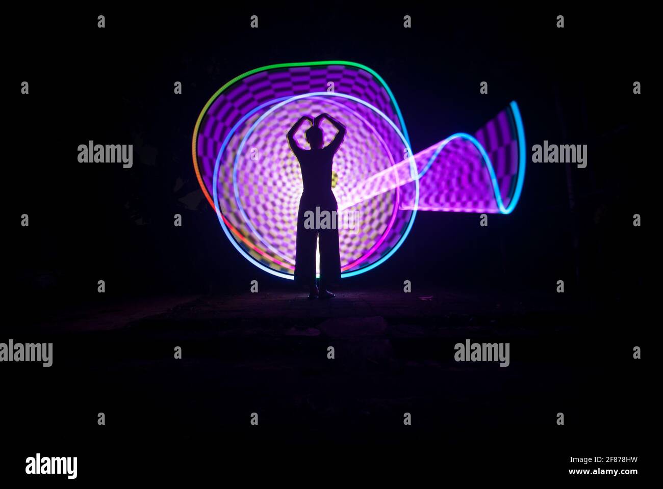 One person standing alone against beautiful color circle LED light ...