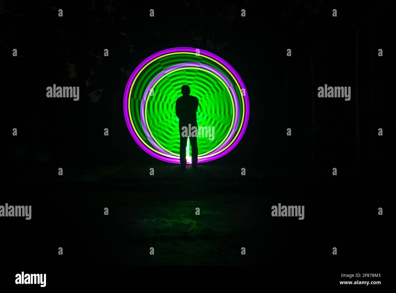 One person standing alone against beautiful color circle LED light ...