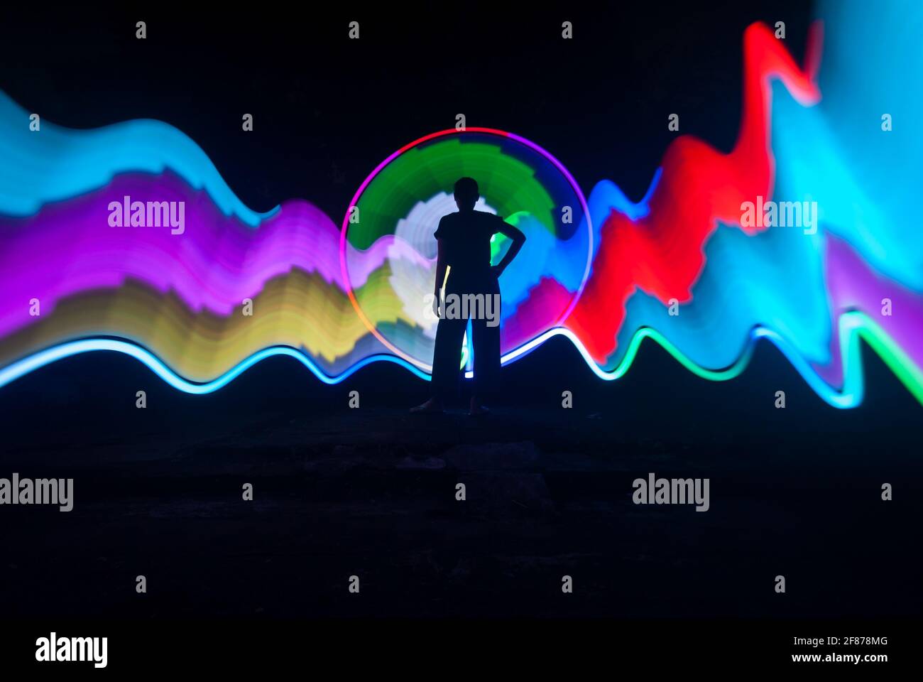 One person standing alone against beautiful color circle LED light ...