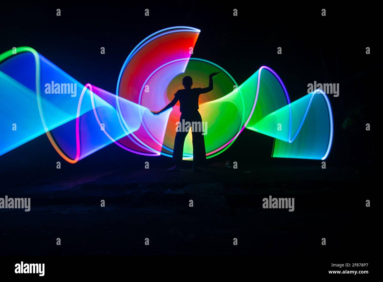 One person standing alone against beautiful color circle LED light ...
