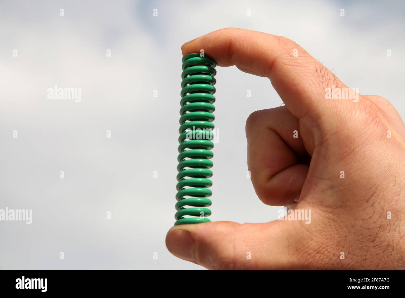 Metal spring in the hands of the engineer. Newly manufactured metal ...