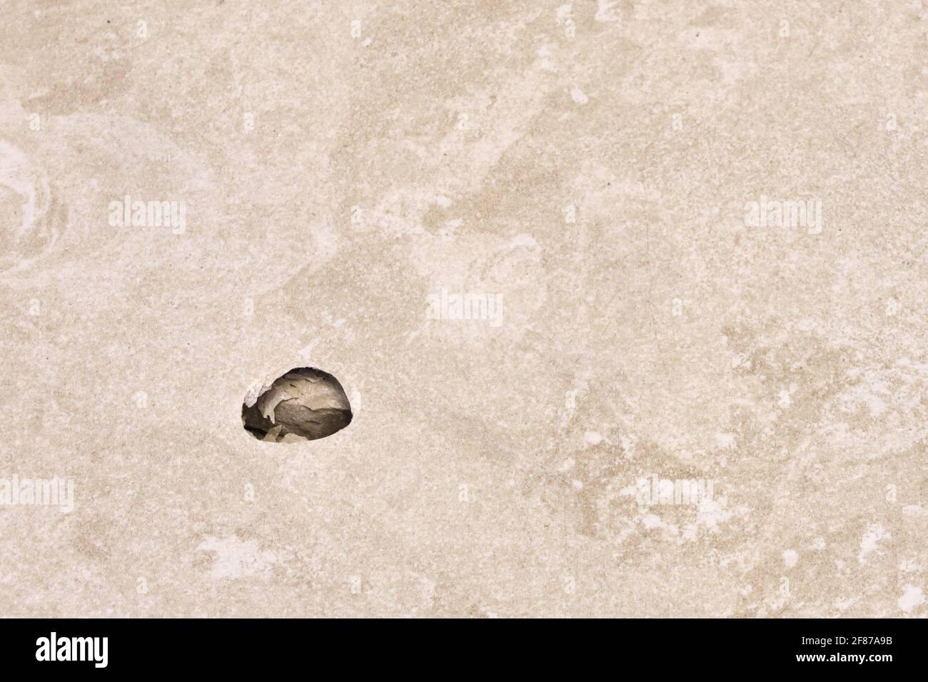 A hole in a beige floor tile, close up of damage Stock Photo - Alamy