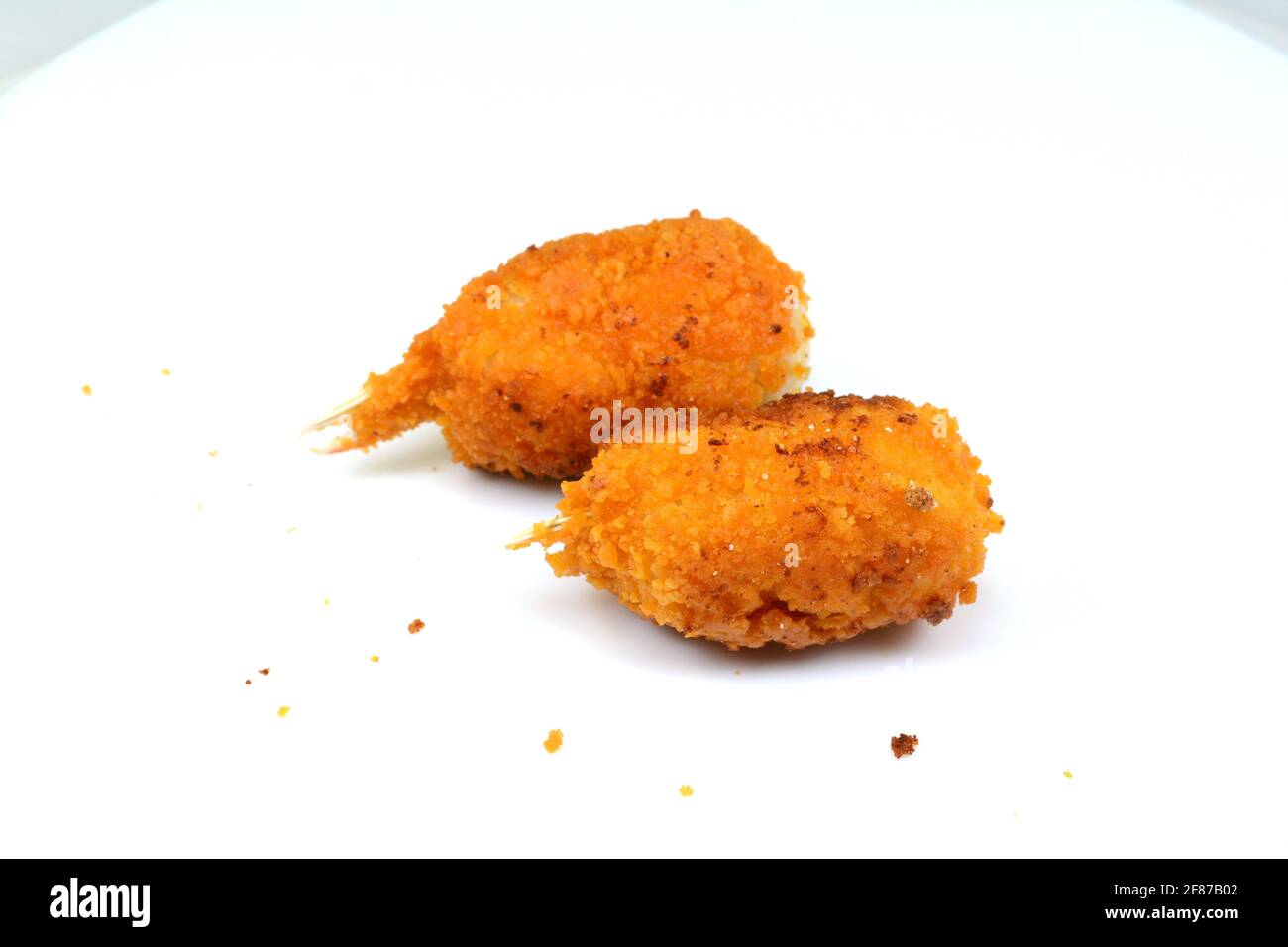 Two fried breaded surimi crab claws, in perspective, isolated on white ...