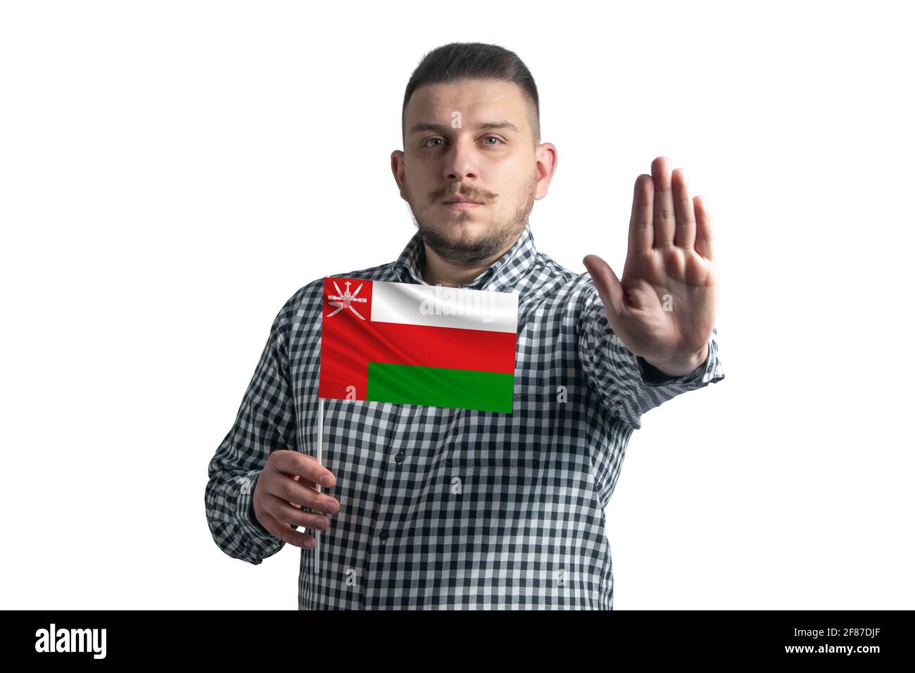 White guy holding a flag of Oman and with a serious face shows a hand ...
