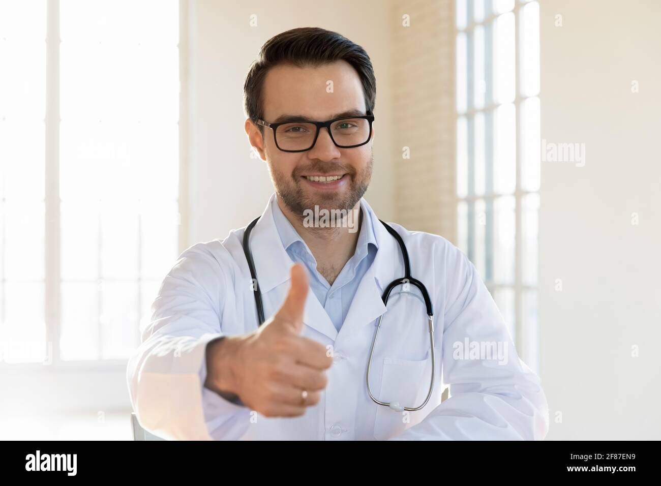 Portrait of smiling male doctor show thumb up Stock Photo - Alamy