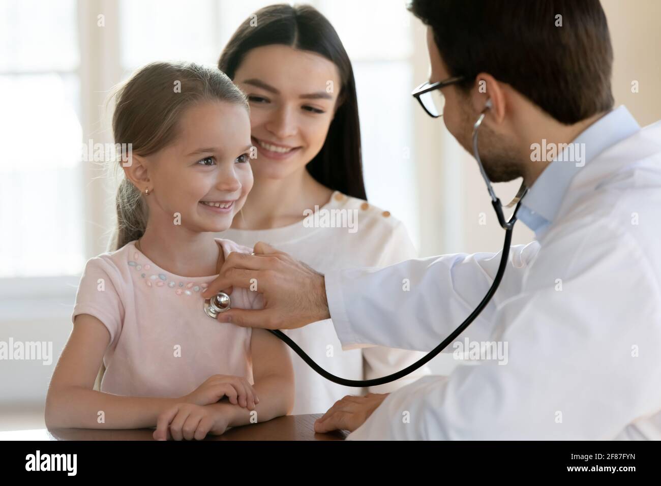 Male pediatrician listen to small child heartbeat with stethoscope ...