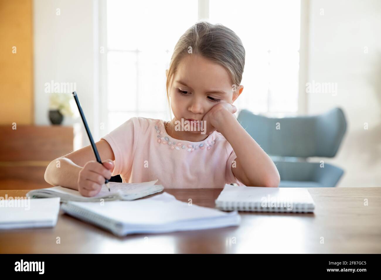 Bored little girl child unmotivated doing homework Stock Photo - Alamy