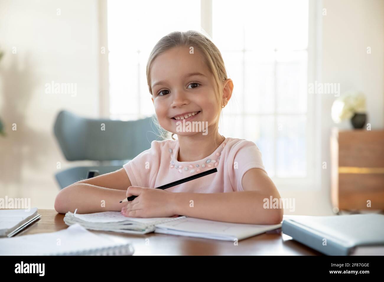 Portrait of smiling little girl study at home Stock Photo - Alamy