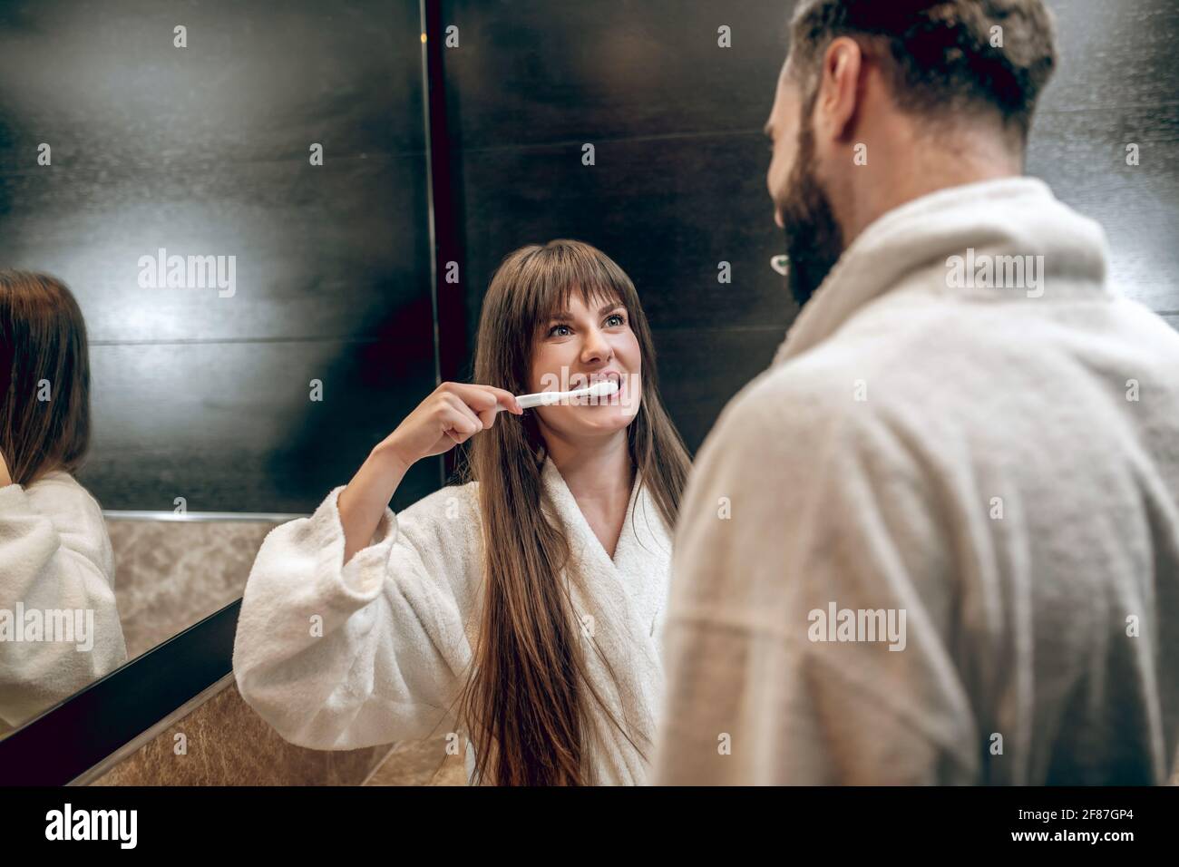 Young couple in bath robes brushing teeth together Stock Photo - Alamy