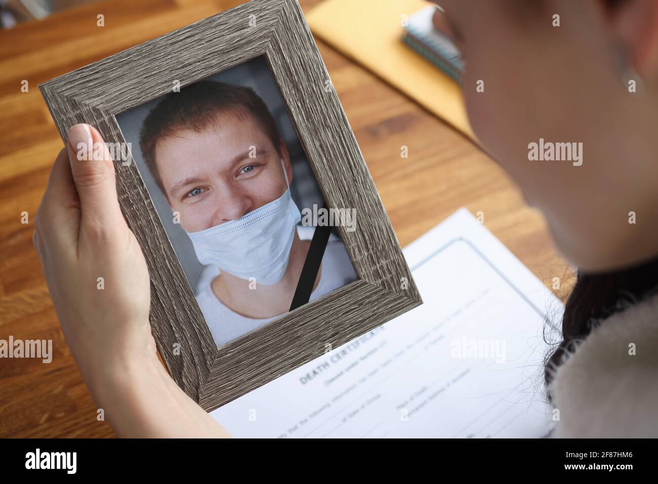 Woman crying over portrait of deceased young man closeup Stock Photo ...
