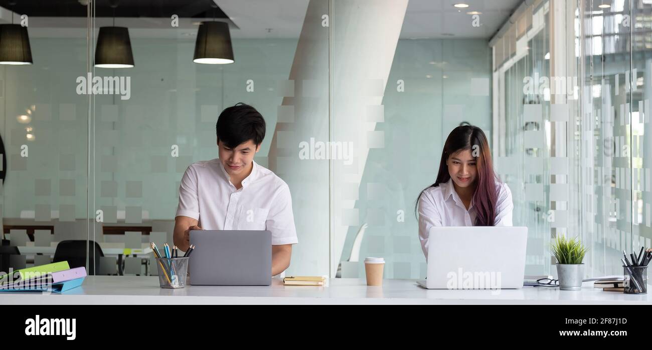 Two business people working with laptop computer at modern office Stock ...